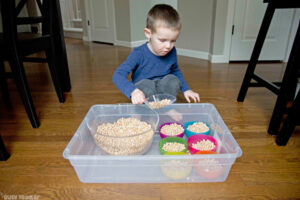 Toddler Scooping Activity with Garbanzo Beans - Busy Toddler