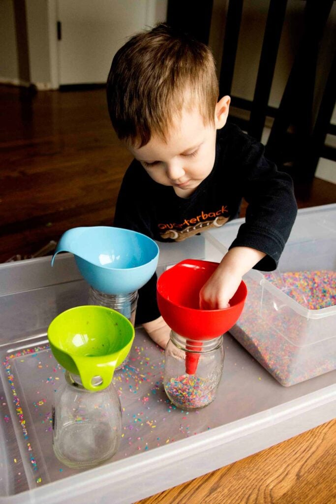 Rainbow Rice and Funnels Sensory Bin - Busy Toddler