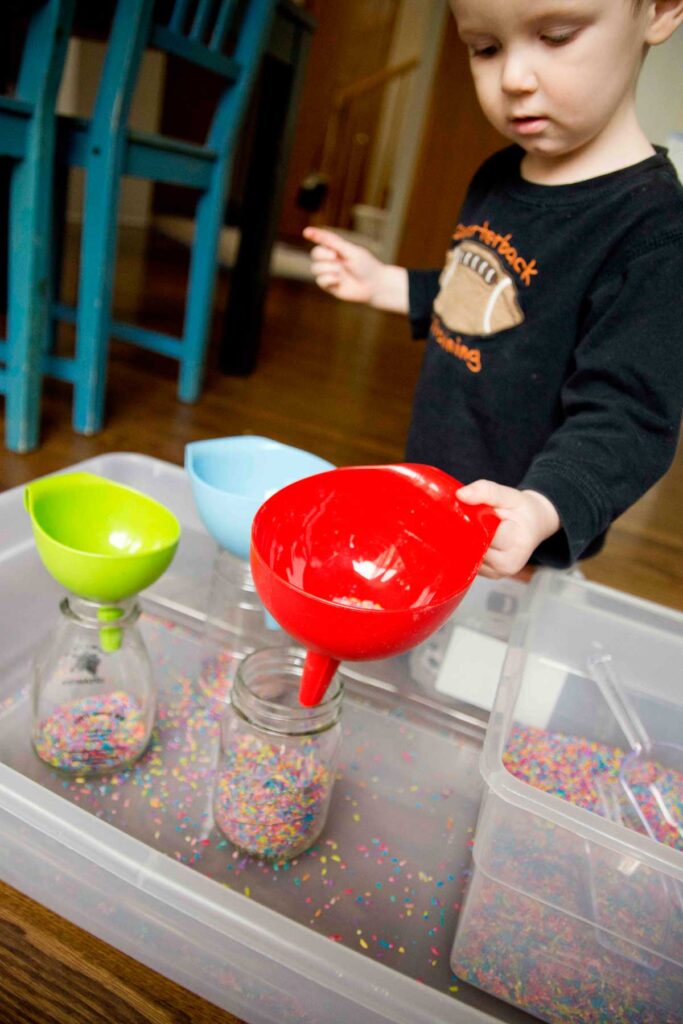 Rainbow Rice and Funnels Sensory Bin - Busy Toddler