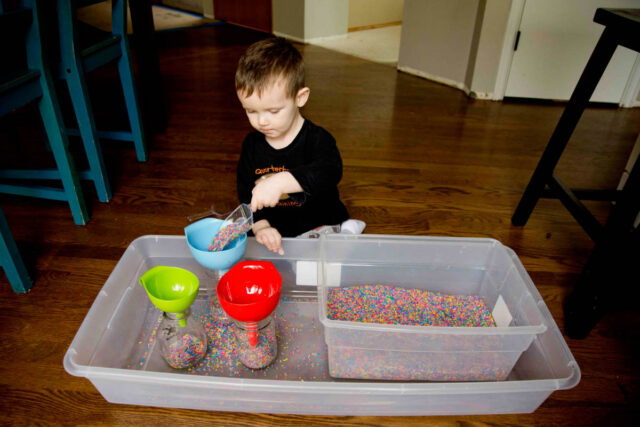 Rainbow Rice and Funnels Sensory Bin - Busy Toddler